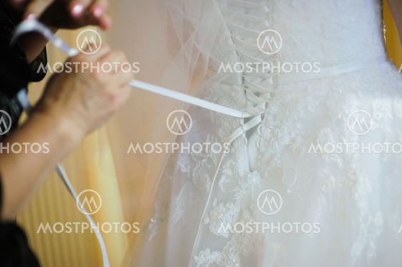 "bride getting dressed on he..." by Evgheni Lachi - Mostphotos